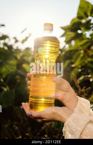 Young women bottle of oil against sunflowers - Image Stock Photo - Alamy