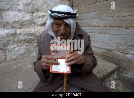 A Palestinian man shows his identification card to Israeli soldiers in ...