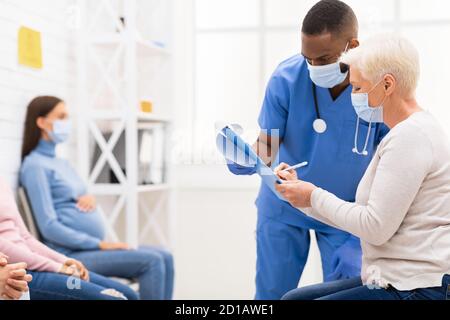 Mature Patient Lady Signing Papers With Doctor In Hospital Stock Photo ...