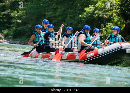 Rafting team goes down the river on the beautiful sunny day. Back view ...