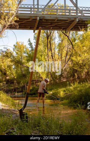 Prospector man uses a metal detector for lost gold treasure from the ...