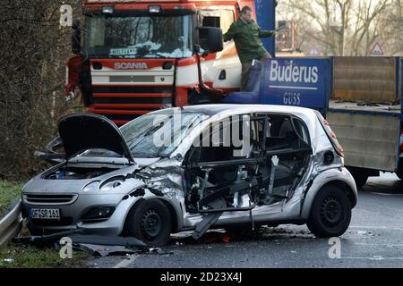 A destroyed car stands in front of the Berlin Wall at the Brandenburg ...