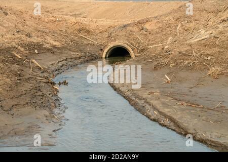 Drainage system under the highway. Concrete pipe under the road. River ...