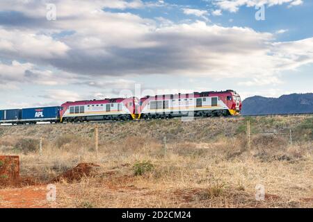 A DF8B diesel locomotive freight train passing by shacks on the SGR ...
