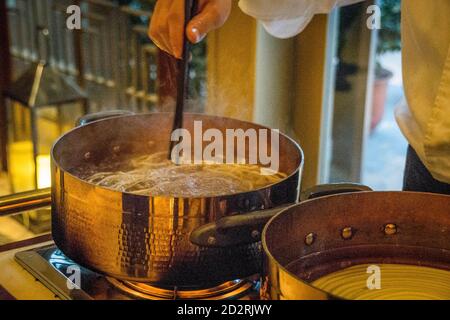 a chinese chef cooking chinese noodles at a live cooking station Stock ...