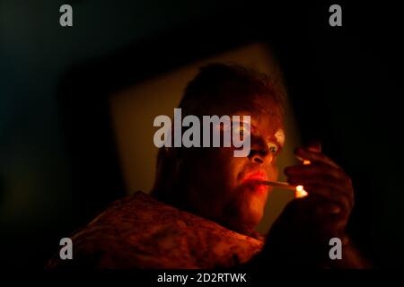 A old man lights a cigarette on the promenade by the sea Stock Photo ...