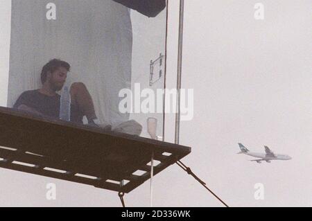 Magician David Blaine sits in a Glass Box suspended alongside the ...