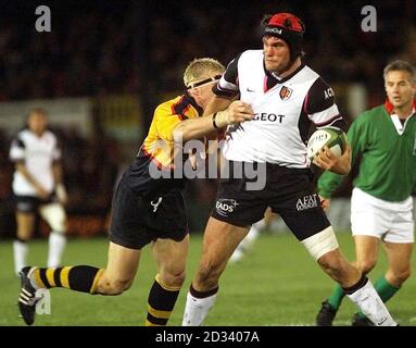 Toulouse's Fabien Pelous (second right) holds off the tackle from ...