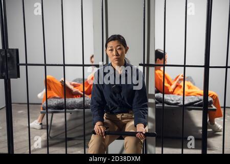 Blonde inmate in an asian women's general security prison is led out of ...