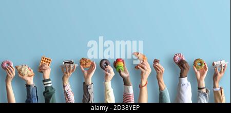People are holding different desserts in their hands. The concept of ...