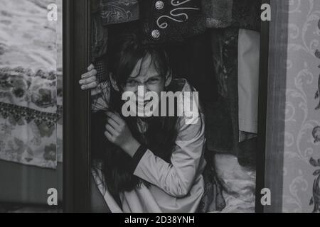 Mad scary girl in cupboard at dark night. Horror background with child ...