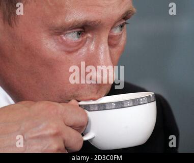 Russian President Vladimir Putin drinks a cup of tea during a meeting ...