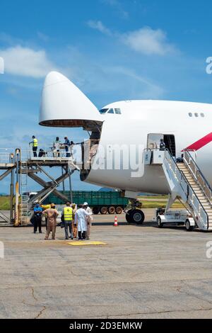 men loading Boeing 747 jumbo jet unloading cargo freight containers ...