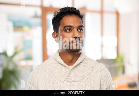 indian man in sweater over office background Stock Photo - Alamy