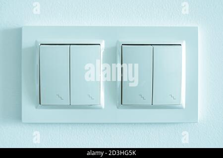 White plastic pass-through electricity switches on a white wall Stock ...