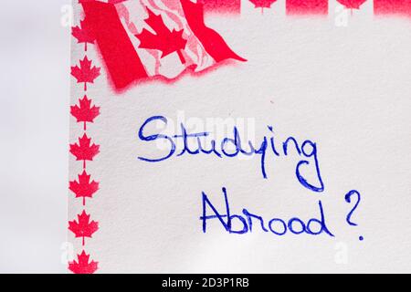 Studying abroad handwriting on paper with Canada flag. Writing text on ...