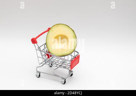 Avocado in shopping grocery cart. Shopping at the supermarket. Fresh ...