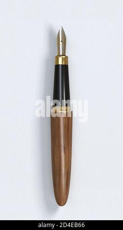 A closeup view of an ornate fountain pen drawing a straight illuminated ...