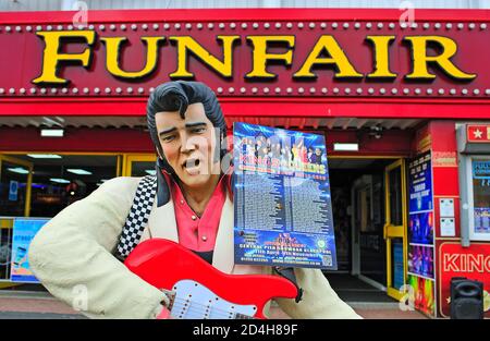 A life-size statue of Elvis Presley adorns the front of a shop on ...