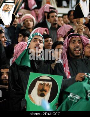 Saudi Arabian football fans hold up their national flags to show ...