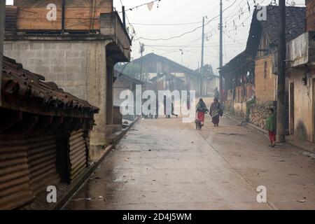 A typical street scene as Ixil Maya people walk along a mud road in the ...