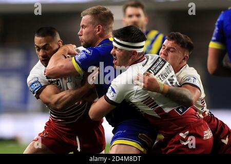 Sam Powell of Warrington Wolves is tackled around the neck by Joe ...