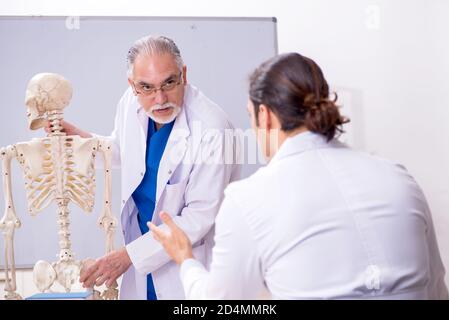 Experienced doctor surgeon teaching young assistant Stock Photo - Alamy