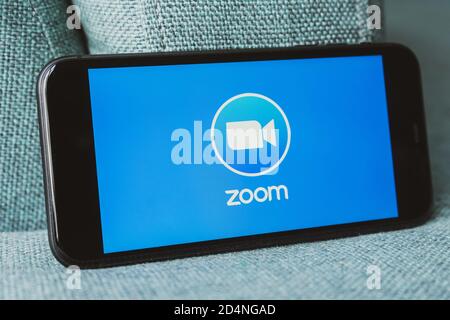 Phone with a hand showing Zoom Cloud Meetings app. Work and have ...