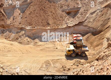 Excavator developing the sand on the opencast and loading it to the ...