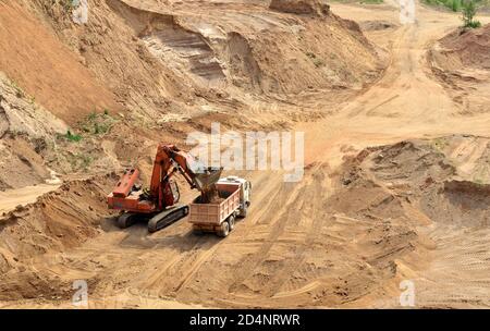 Excavator developing the sand on the opencast and loading it to the ...