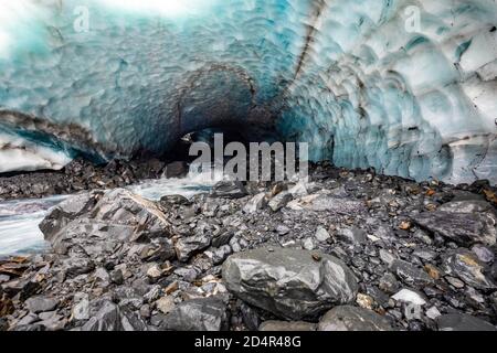 Scenic glacier ice caves with river flowing out from inside nobody ...