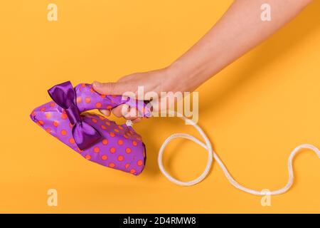 Iron wrapped in purple gift paper on an orange background Stock Photo ...