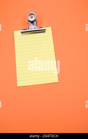 Vertical shot of a notepad with a paper clipper and a pencil isolated ...