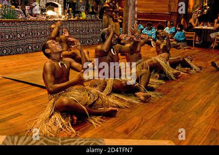 A group of Fijians in national dress giving an evening performance ...