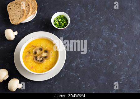 Closeup of white soup with cut onions, parsley, and bread on the ...