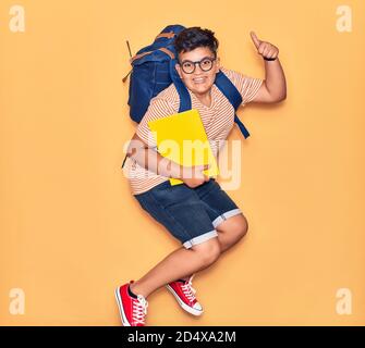 Cheerful hispanic school boy wearing headphones, smiling at camera ...