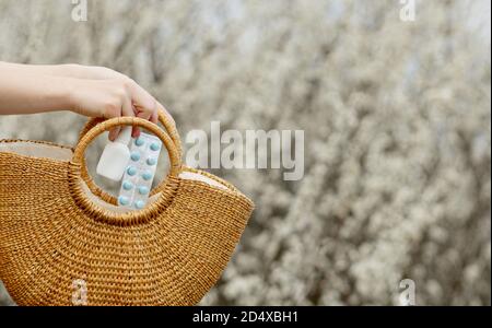 Woman's hand puts allergy pills in bag on blooming background Stock ...