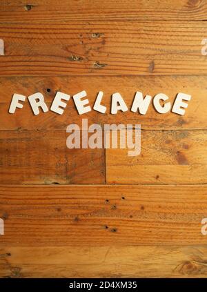 Wooden letters, word freelance on yellow background Stock Photo - Alamy