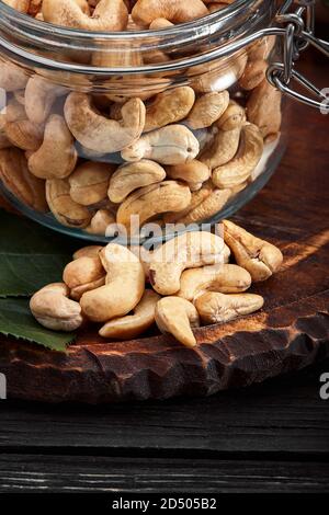 top view of pile of raw cashew seeds close up on gray ceramic plate ...