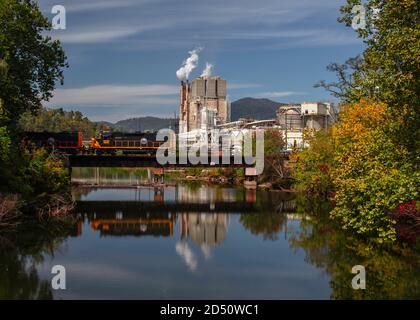 Train passes the old industrial town of Bagou Stock Photo - Alamy