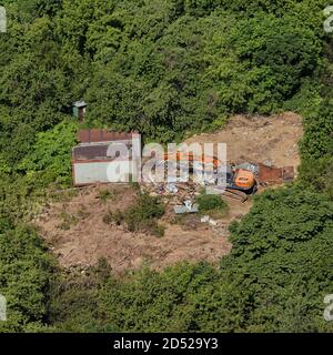 Disassembly of buildings in the forest by construction machines Stock ...