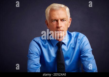 Close-up shot of an executive elderly professional man standing at ...