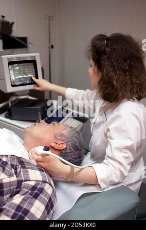 Female nurse performs a Carotid Duplex Test on an adult female Stock ...