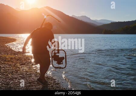 videographer taking action shot of triathlon athlete while riding bike ...