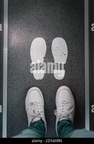 A vertical shot of a person's feet near the Stop here sign Stock Photo ...