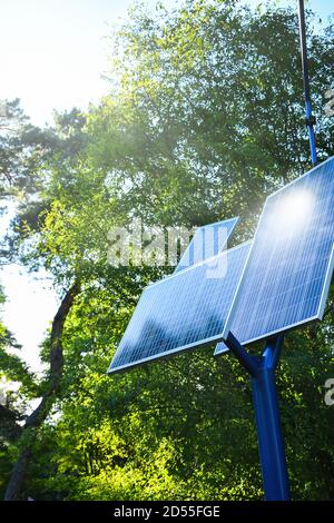 Solar panels stand against green mountains and blue sky at a ...