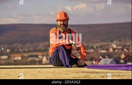 in work clothes. roofer working on roof structure of building on ...