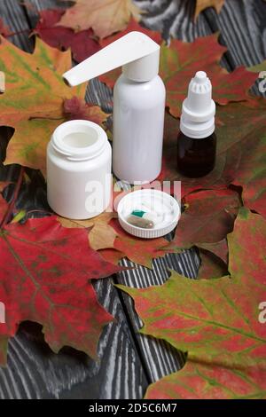 Tablets on autumn leaf. Autumn maple leaf and medicines on blue ...