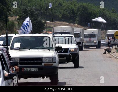 A convoy of UNHCR trucks carrying humanitarian aid, waits on the ...