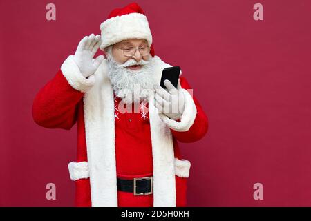 Santa Claus using smartphone - calling phone or texting a message ...